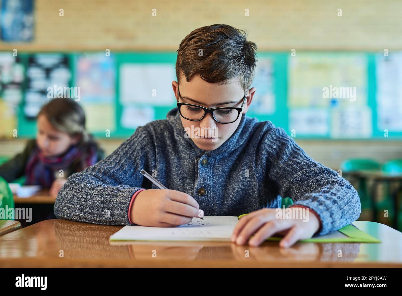 Working hard to complete his worksheet. an elementary school boy ...
