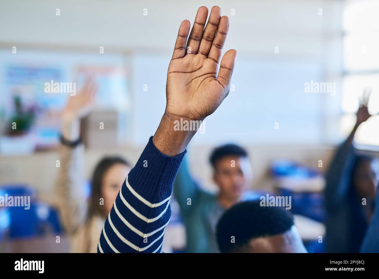 He knows all the answers. an unrecognizable varsity student raising his ...