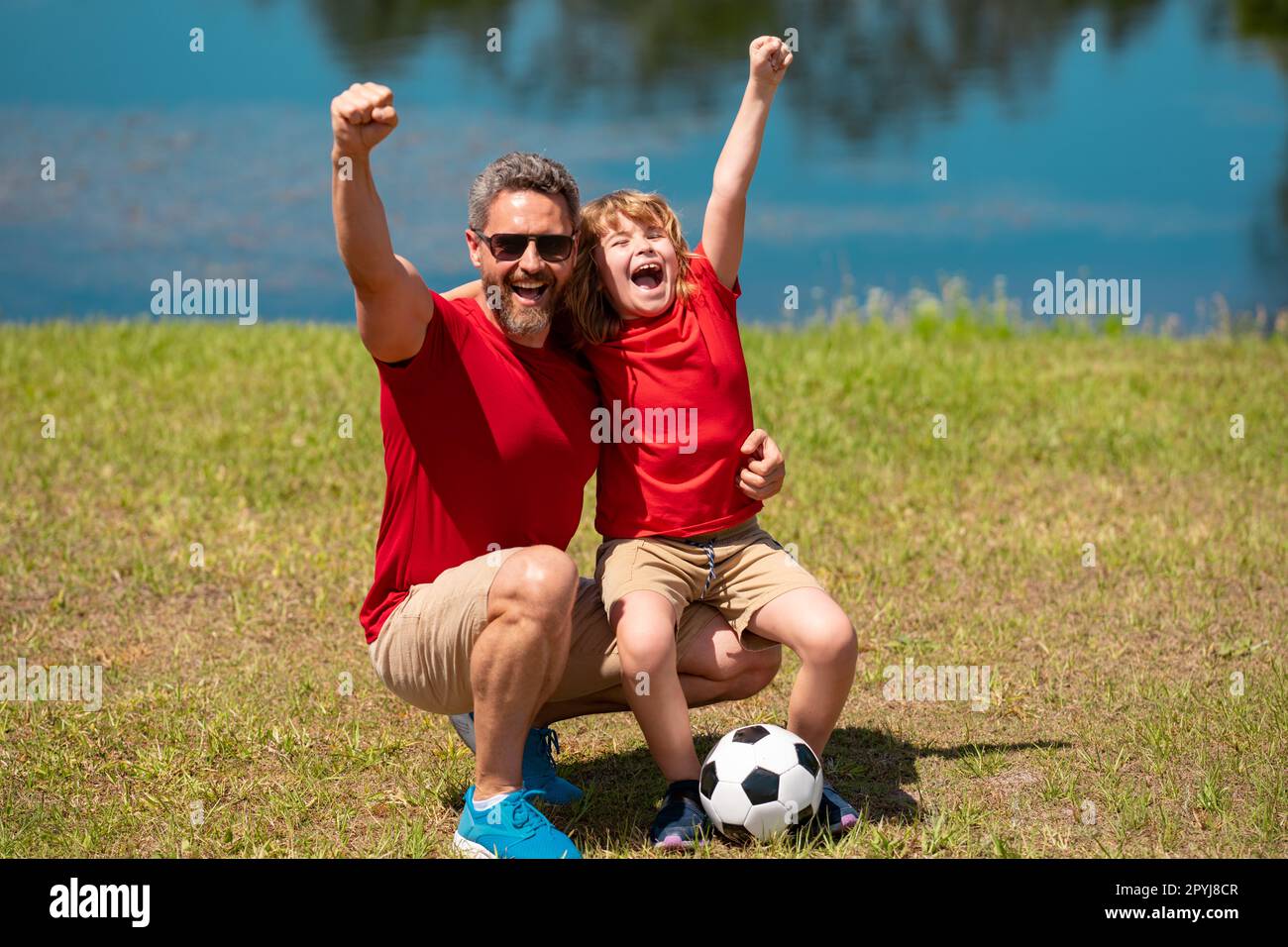 Dad with his little cute son are having fun and playing football on ...