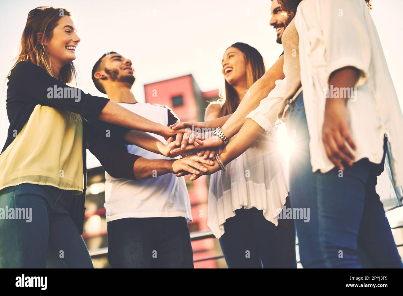 In it to win it. a group of young people putting their hands together ...