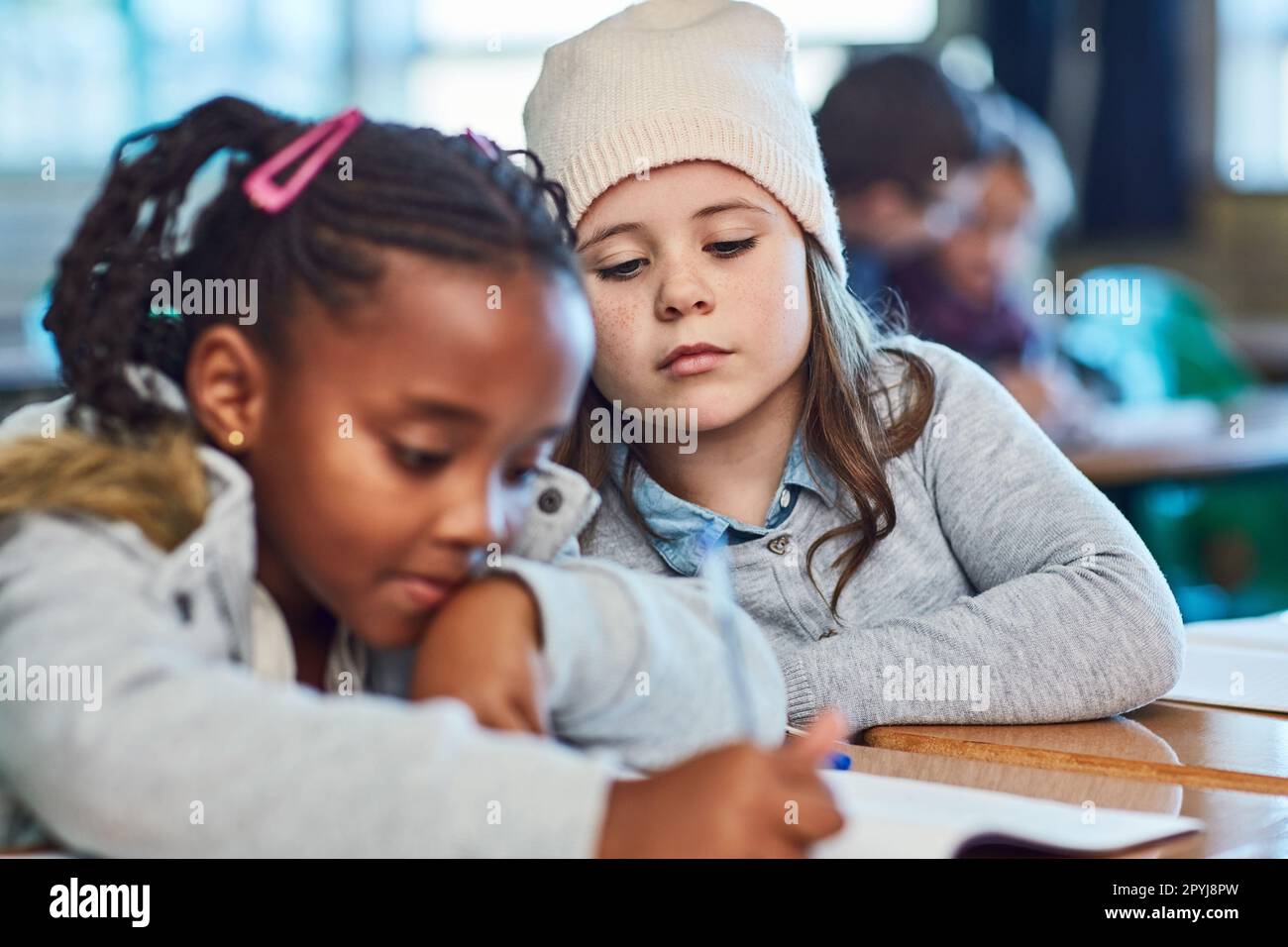 Working together. elementary school girls doing school work together in the classroom Stock ...