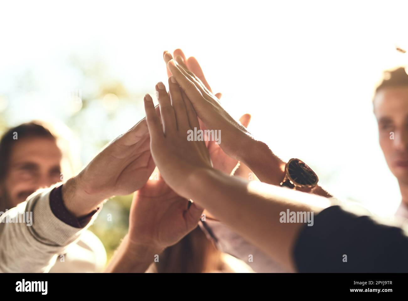We rise when we lift each other up. a group of colleagues joining hands ...