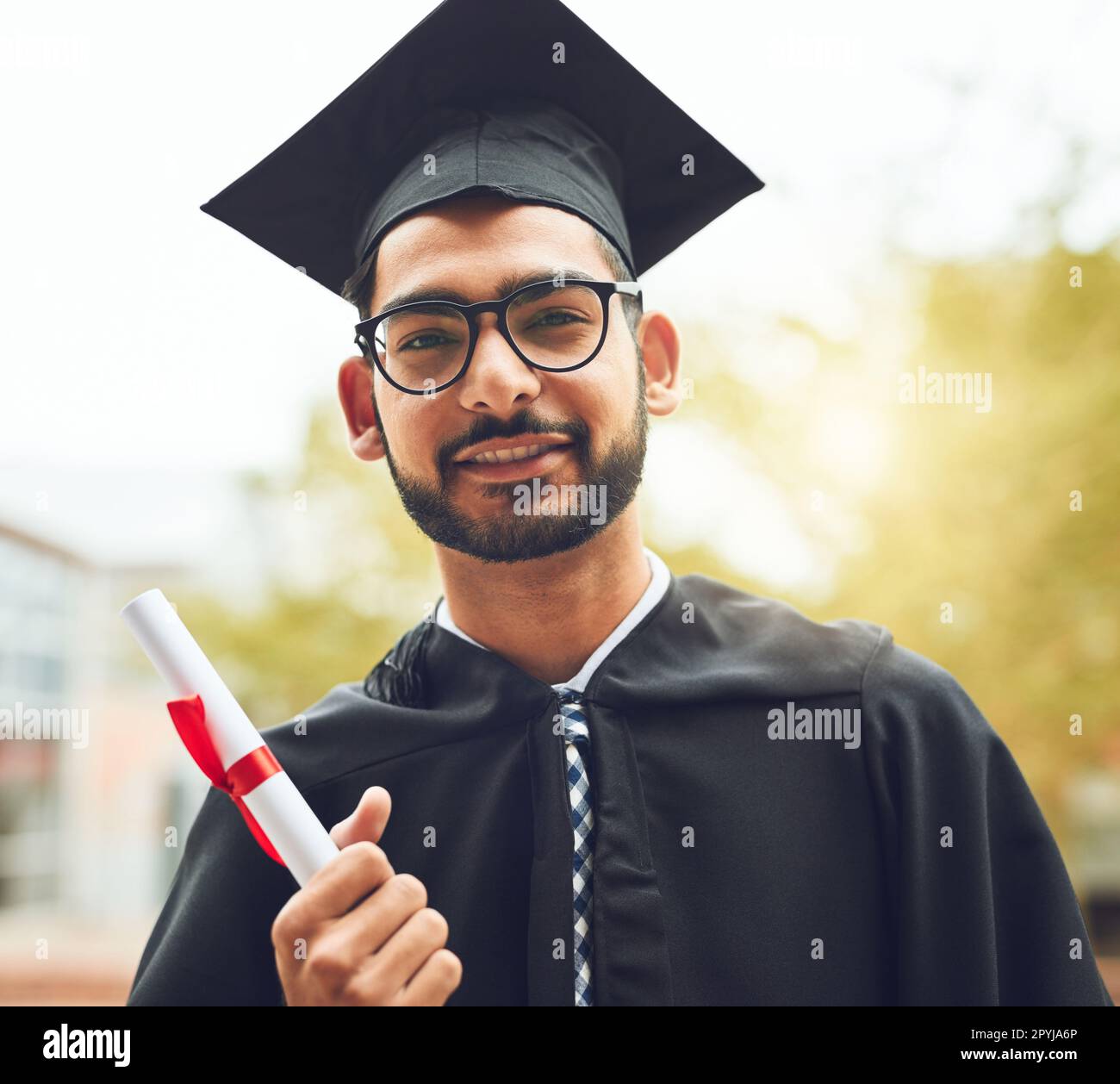 Success is a series of small wins. a happy graduate holding his diploma ...