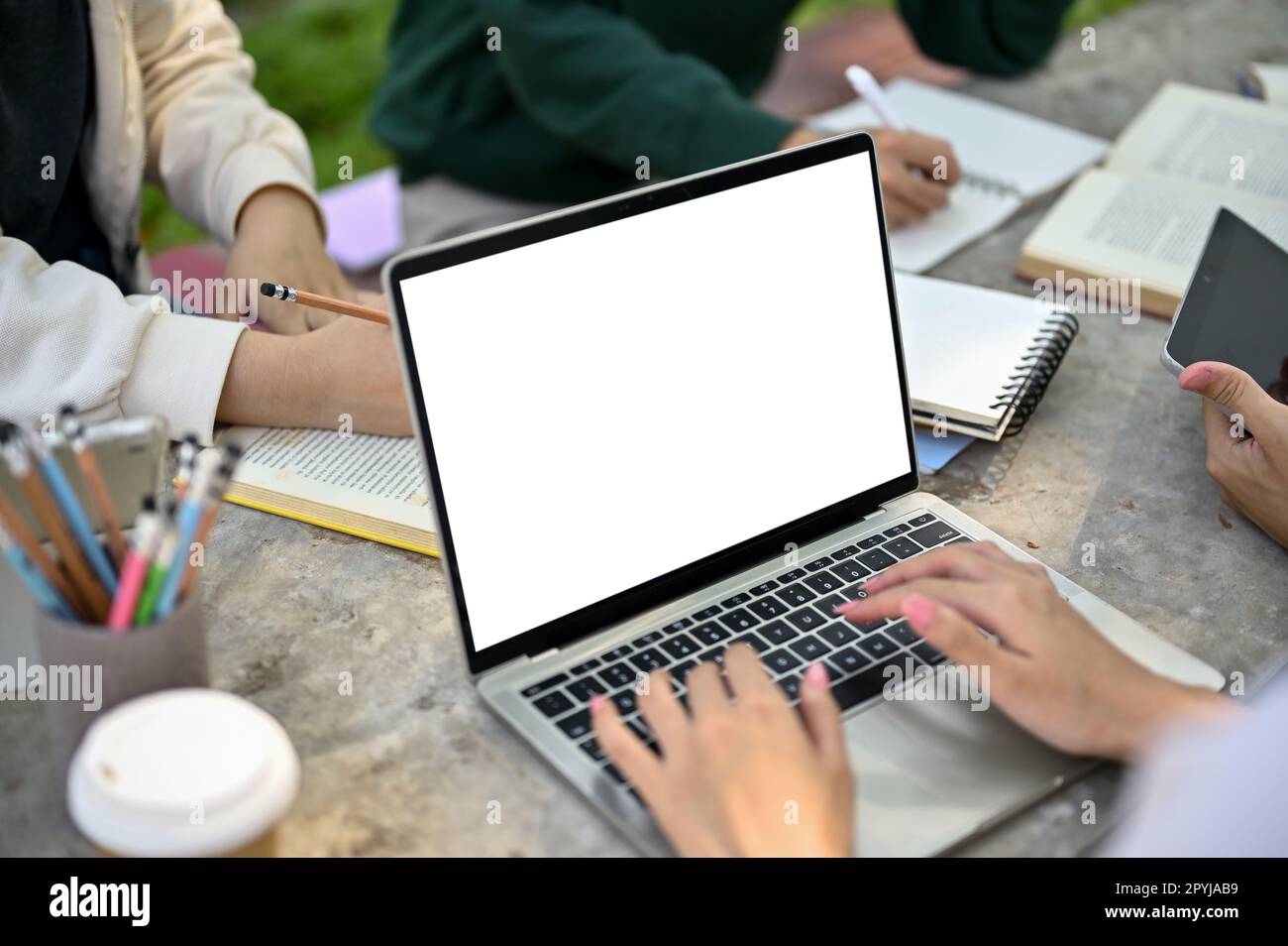 Cropped image of a female college student using her laptop computer and ...