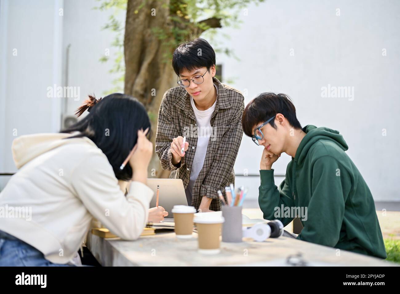 Smart young Asian male college student explained and helped his friends ...