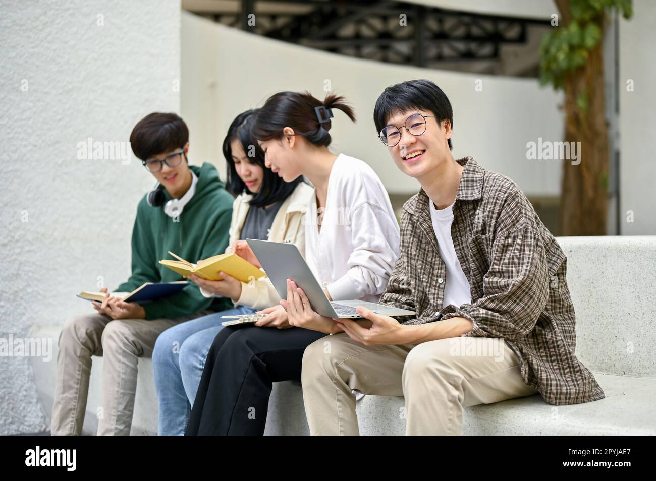 Smart and happy young Asian male college student in casual clothes and ...