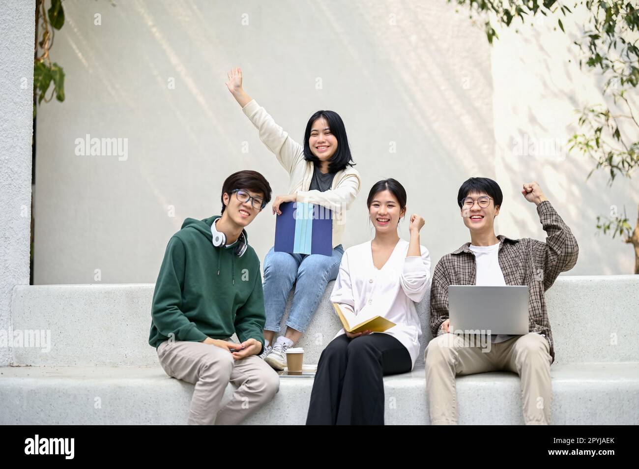 Image of happy and cheerful Asian college students sitting on a bench ...
