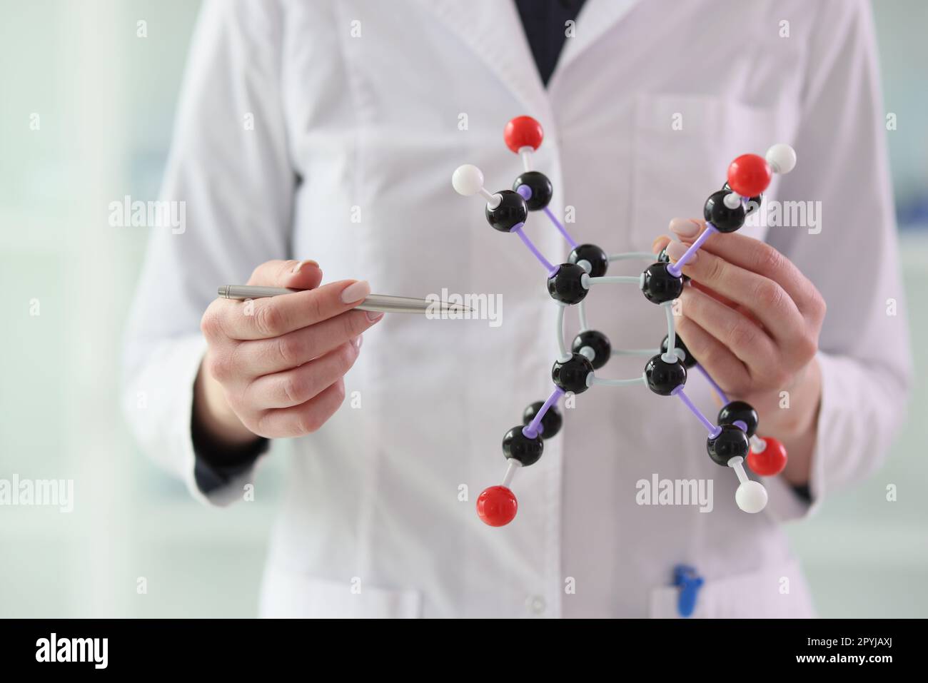 Woman chemist points pen to molecule model holding in hand Stock Photo ... Woman chemist points pen to molecule model holding in hand Stock Photo ...