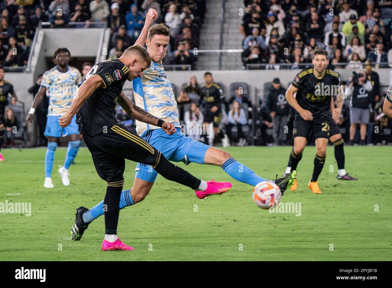 LAFC midfielder Mateusz Bogusz (19) has his shot blocked by ...