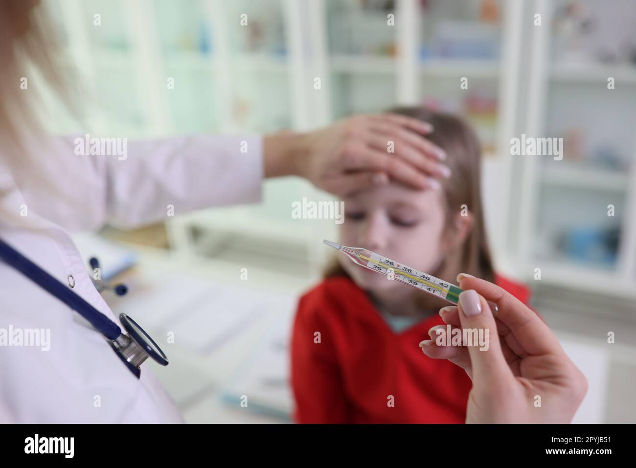 Medic puts hand on girl forehead holding checking thermometer Stock ...