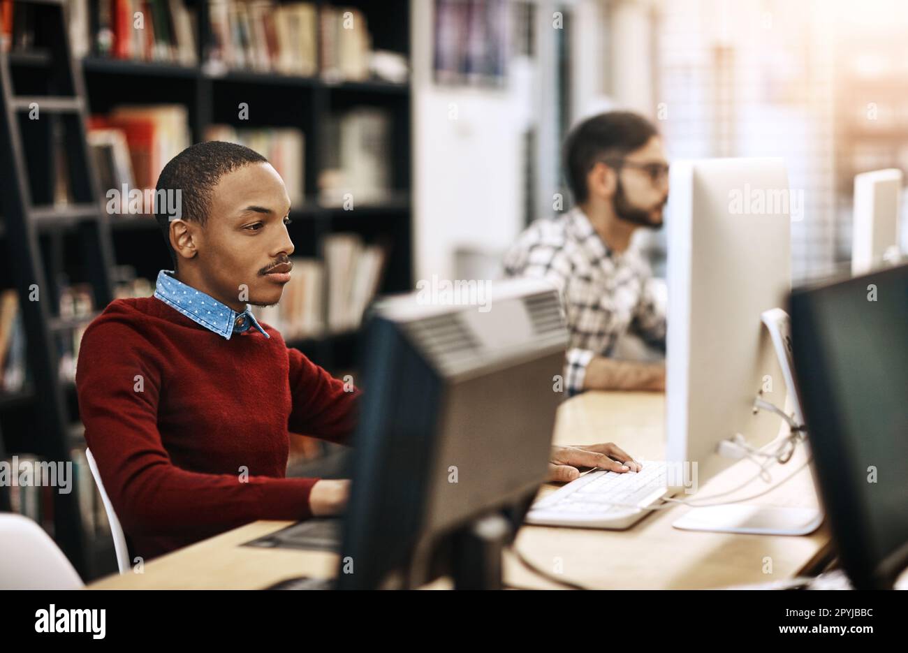 The internet helps them learn loads more. university students working on computers in the ...