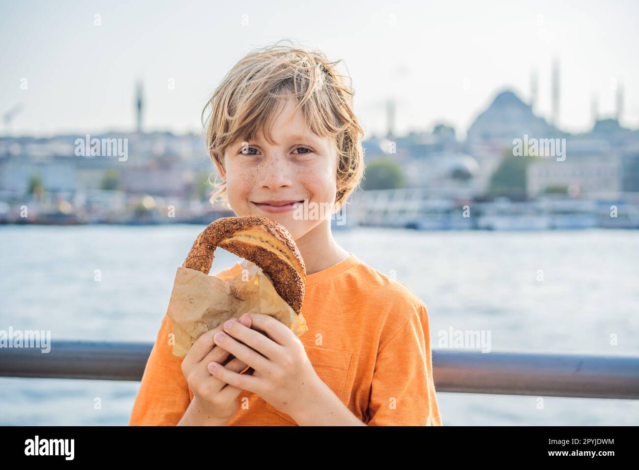 Boy in Istanbul having breakfast with Simit and a glass of Turkish tea ...