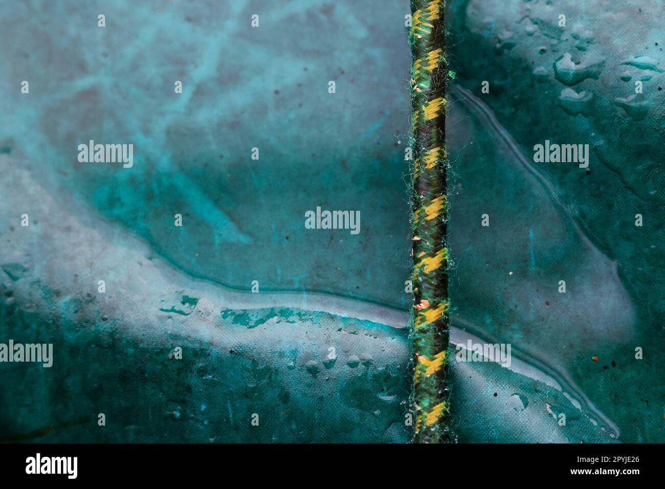 rope wrapped around a wet tarp Stock Photo - Alamy