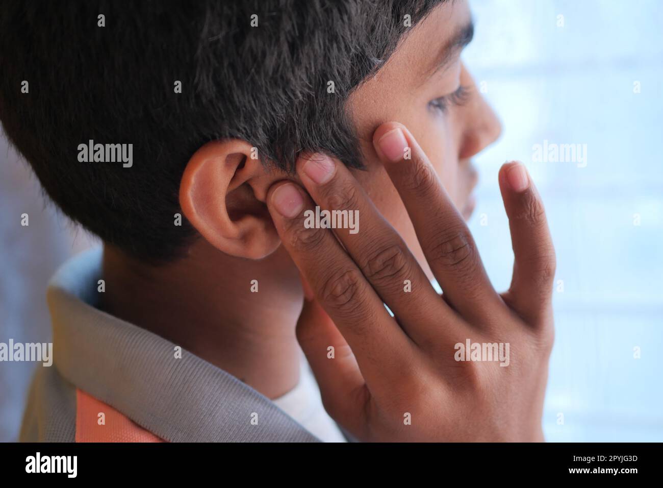 teenage boy having ear pain touching his painful ear Stock Photo - Alamy