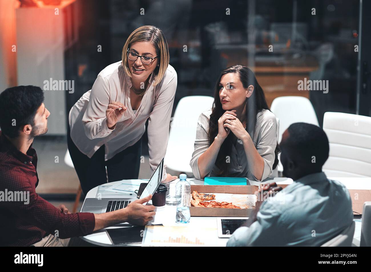 Taking their dedication through the night. colleagues having a meeting ...