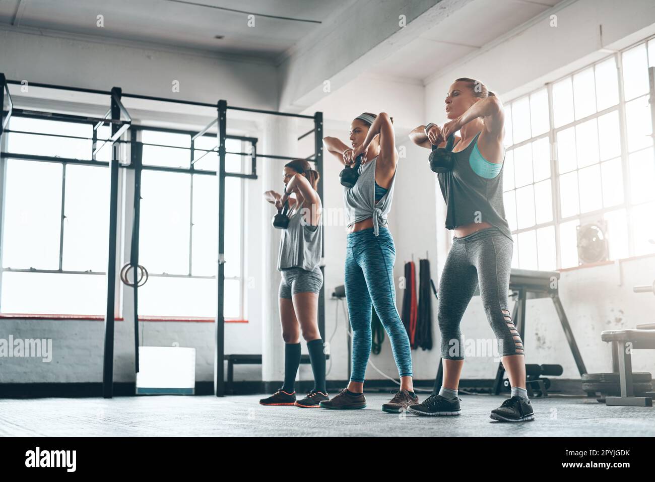 Be your own hero. three young women working out together Stock Photo ...