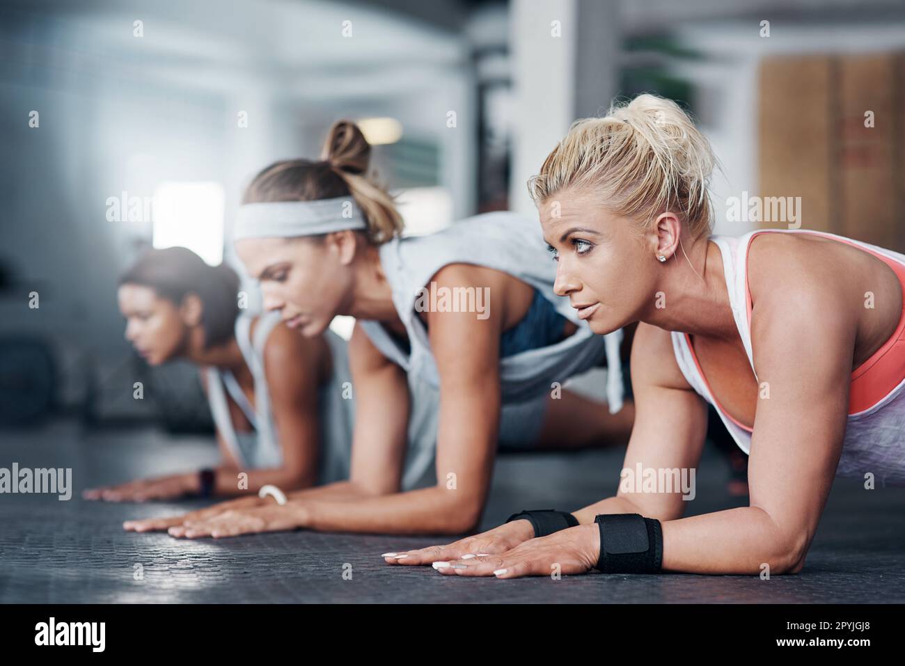 Be the best you can be. three women doing pushups at the gym Stock ...