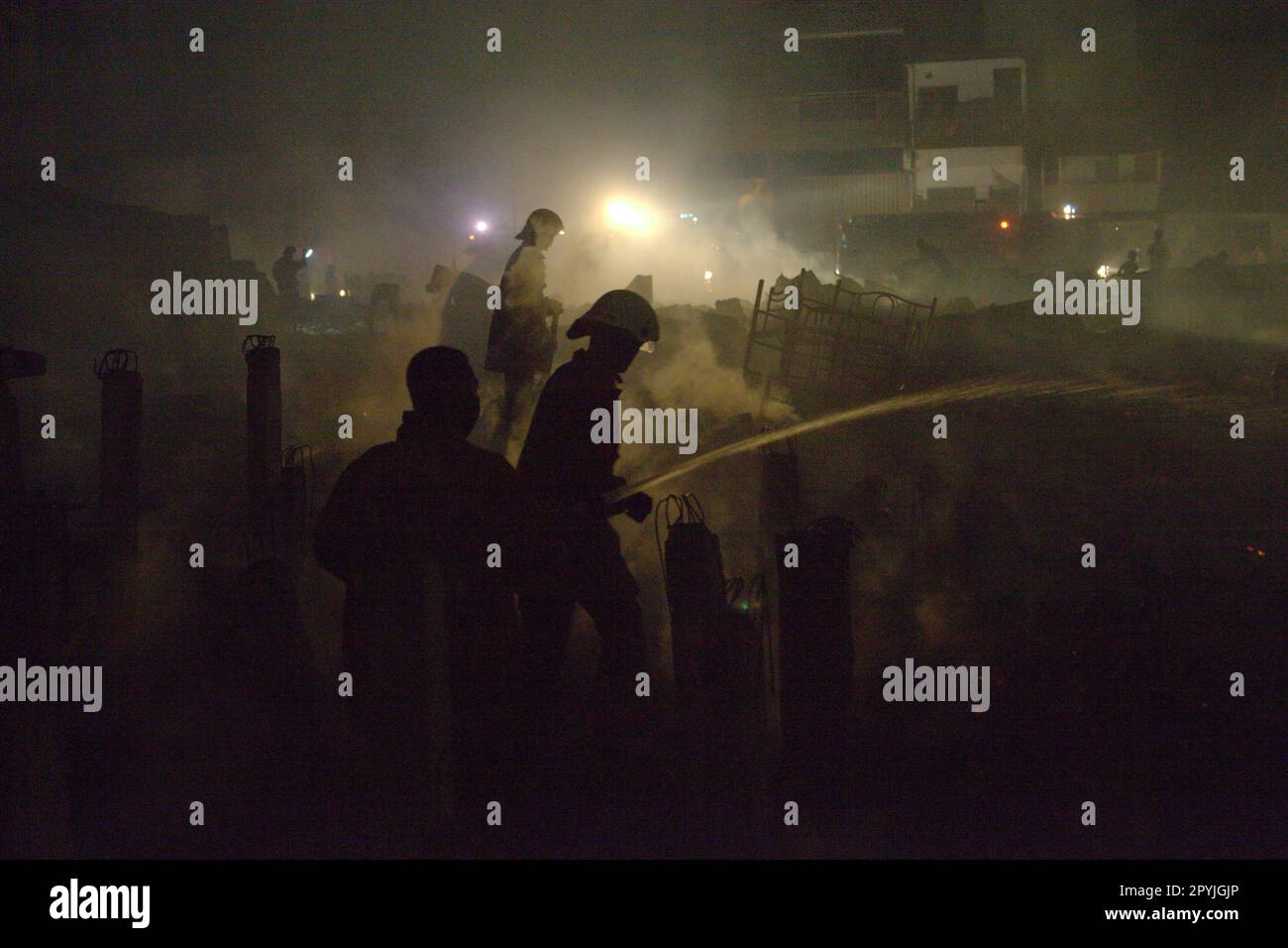 Firefighters performing the cooling phase after a fire accident burned ...