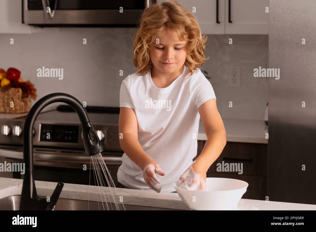 Child cleaning dishes with sponge. Cleaning supplies. Help clean-up ...