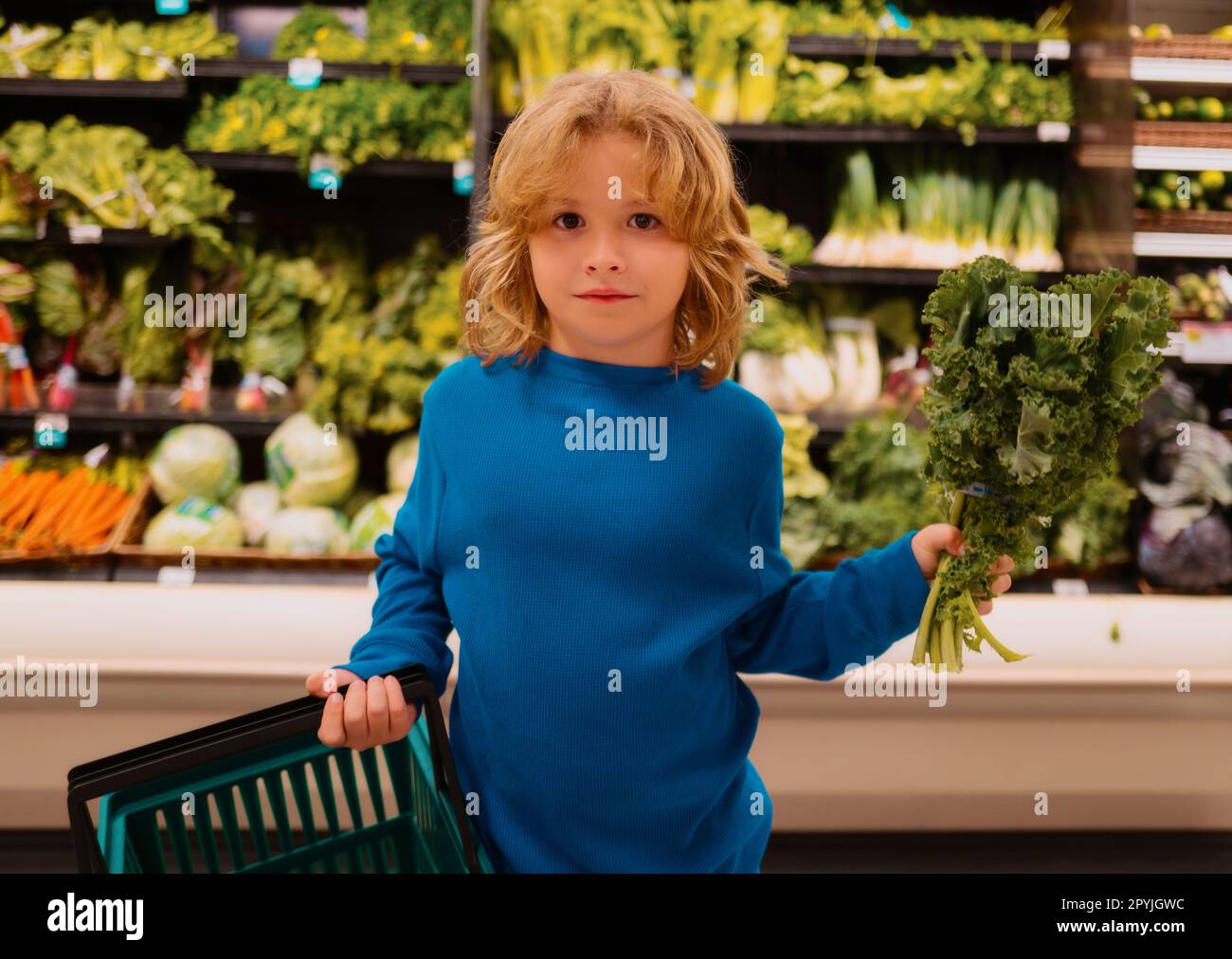 Child with shopping basket and fresh vegetables. Little child choosing ...