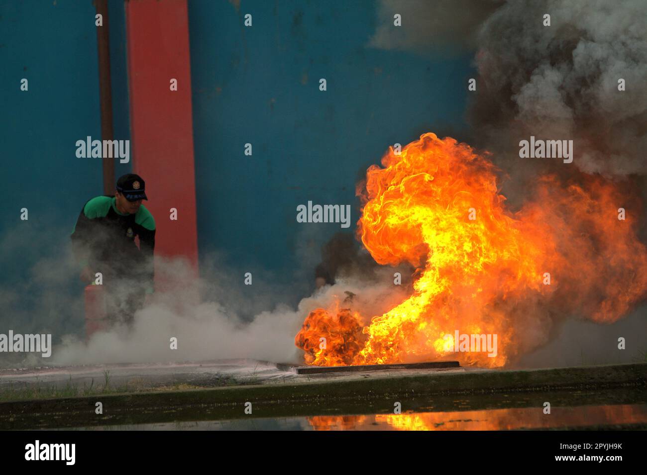A contestant performing a firefighting technique during a competition ...