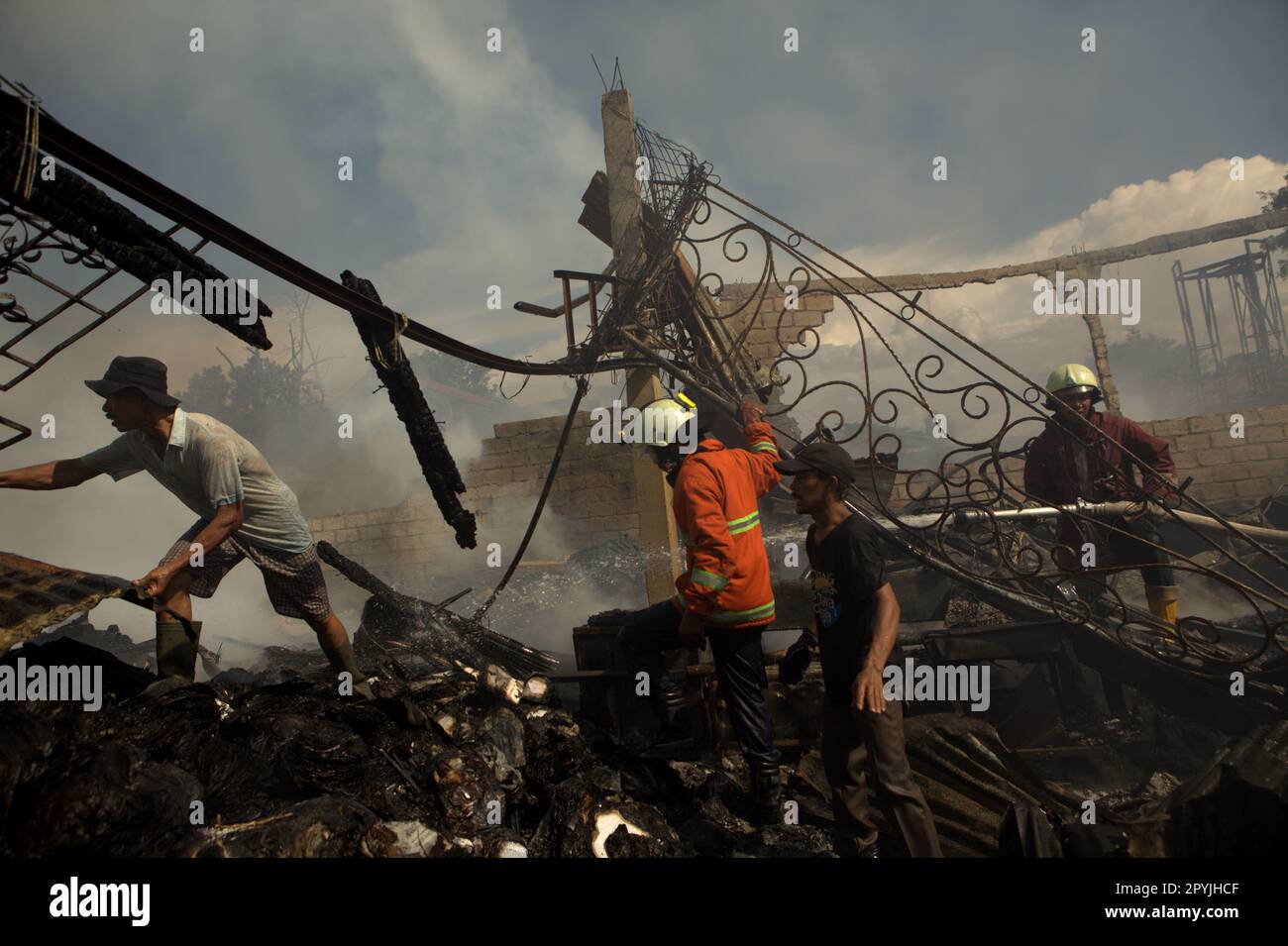 Members of Jakarta firefighting squad and local people working between ...