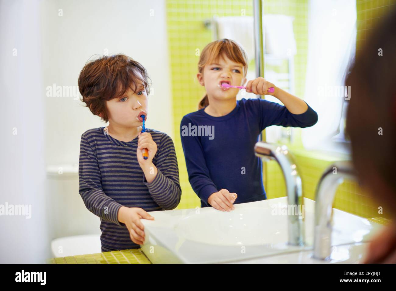 Children brushing teeth in home bathroom with toothbrush for hygiene ...
