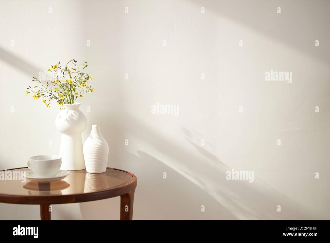 Vases and objects on the table in a warm room with sunlight coming in ...