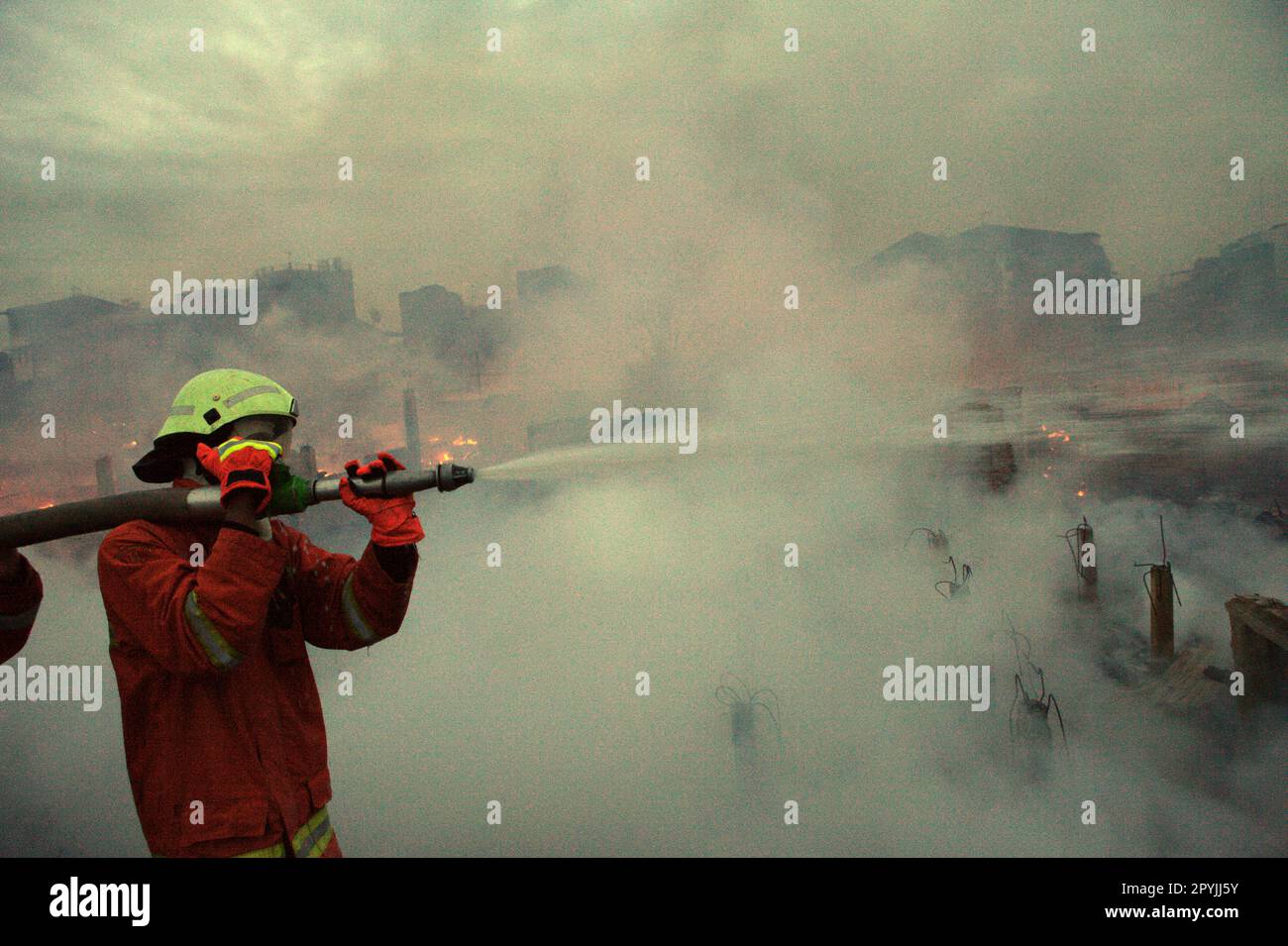Firefighters performing the cooling phase after a fire accident burned ...