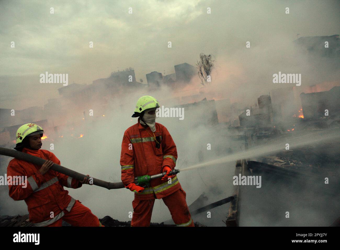 Firefighters performing the cooling phase after a fire accident burned ...