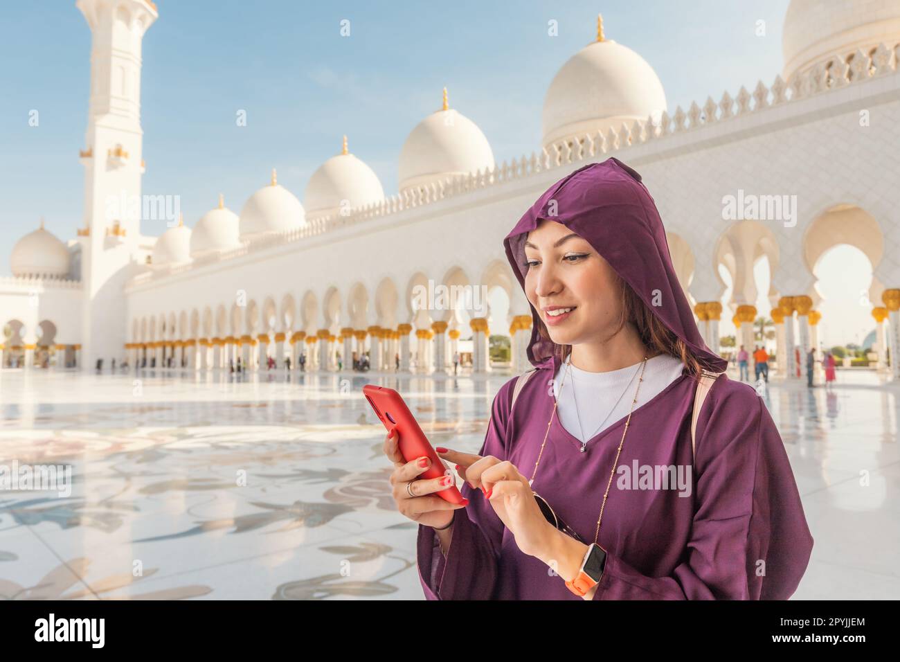 The modern and the ancient come together as a tourist girl using wi-fi ...