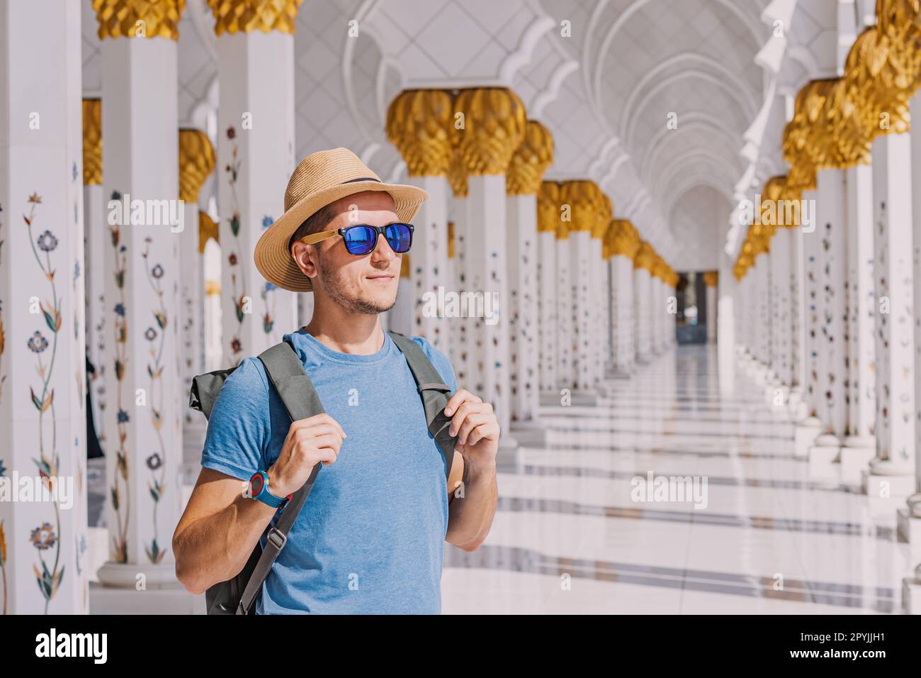 a tourist man in hat with backpack walking through the Great Mosque of ...