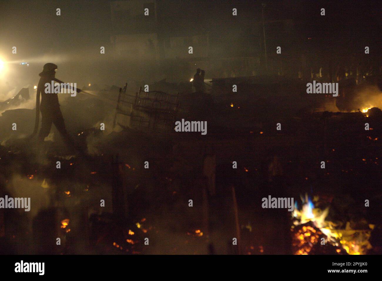 Firefighters performing the cooling phase after a fire accident burned ...