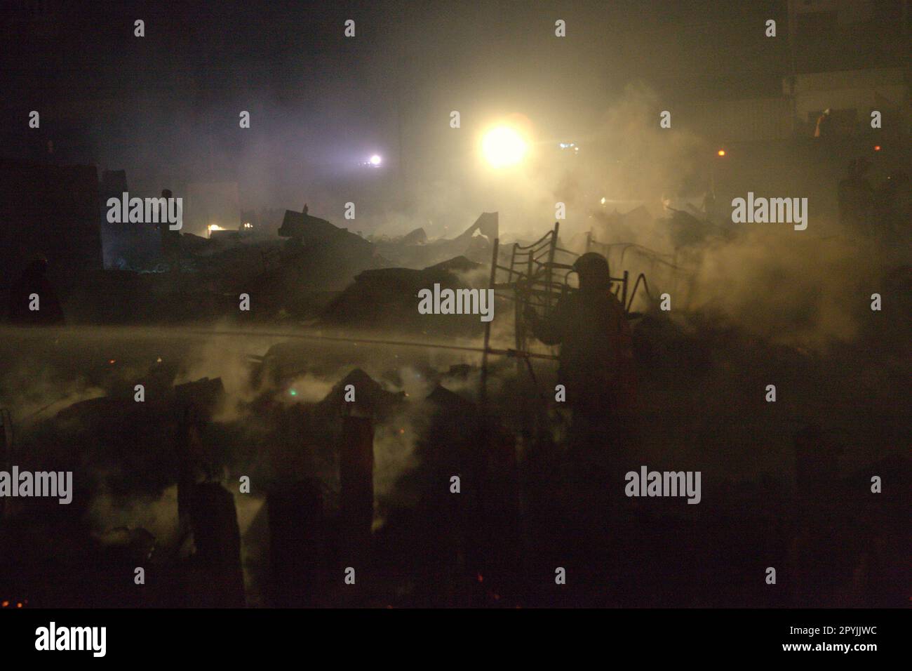 Firefighters performing the cooling phase after a fire accident burned ...