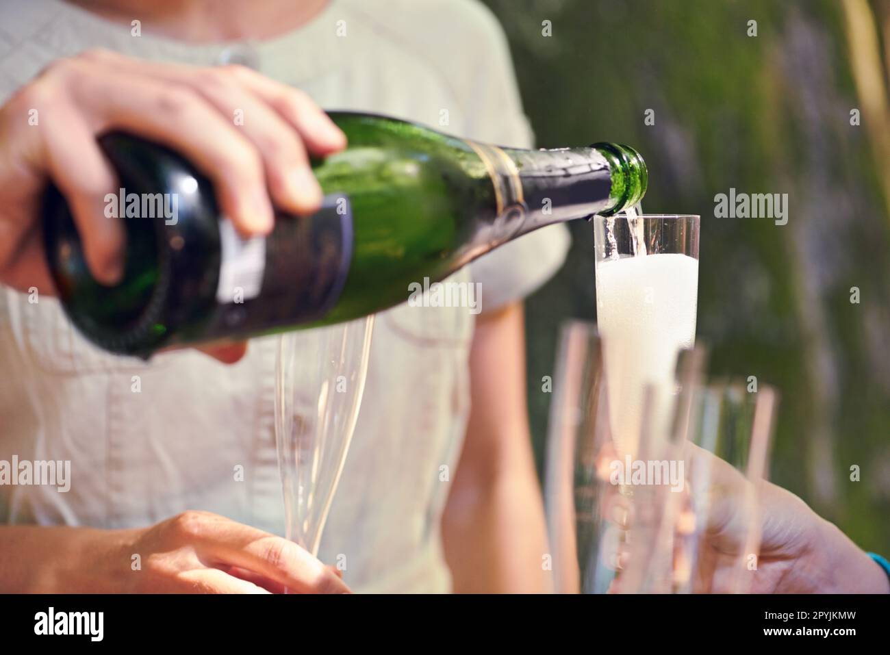 Hand, pour champagne and glasses for group of friends for celebration ...