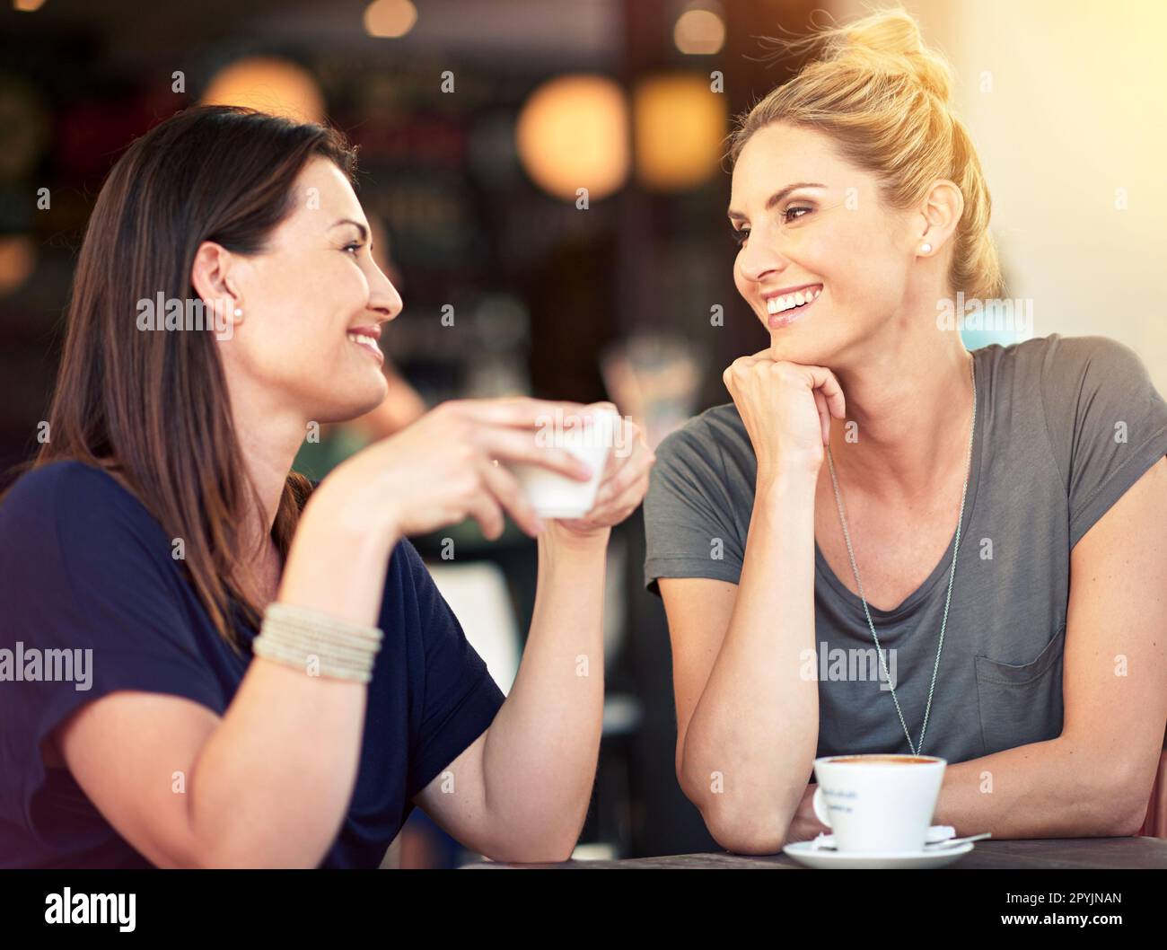 Conversation, cafe and female friends drinking coffee together while ...