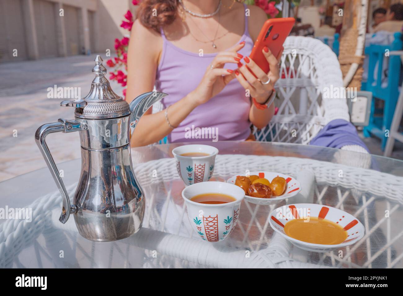 A girl in Dubai savors the combination of Arab coffee and dates in a ...