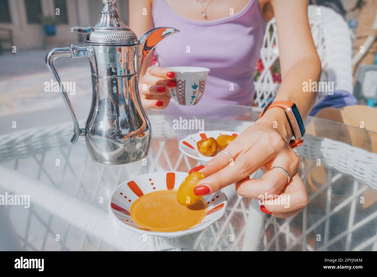 As she sits in a traditional cafe in the UAE, a girl sips on fragrant ...