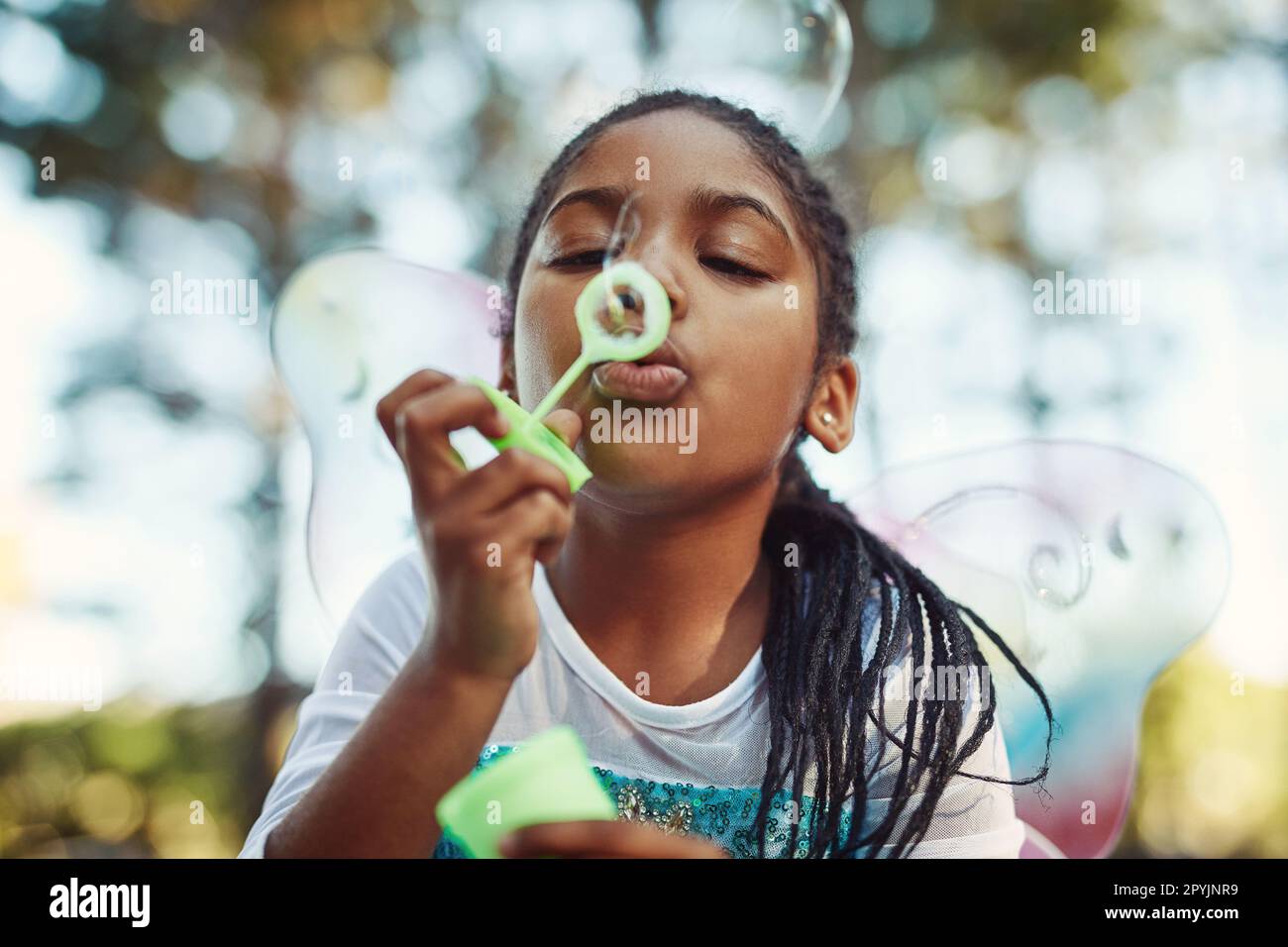 Bubbles are her fairy dust. a little girl dressed up as a fairy and ...