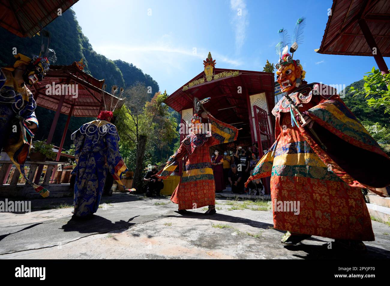 Monks wearing magnificent costumes and masks perform prayers before the ...