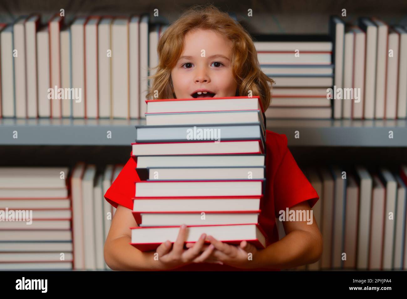 Excited school kid hold stack of books. Surprised school kid. Schoolboy ...