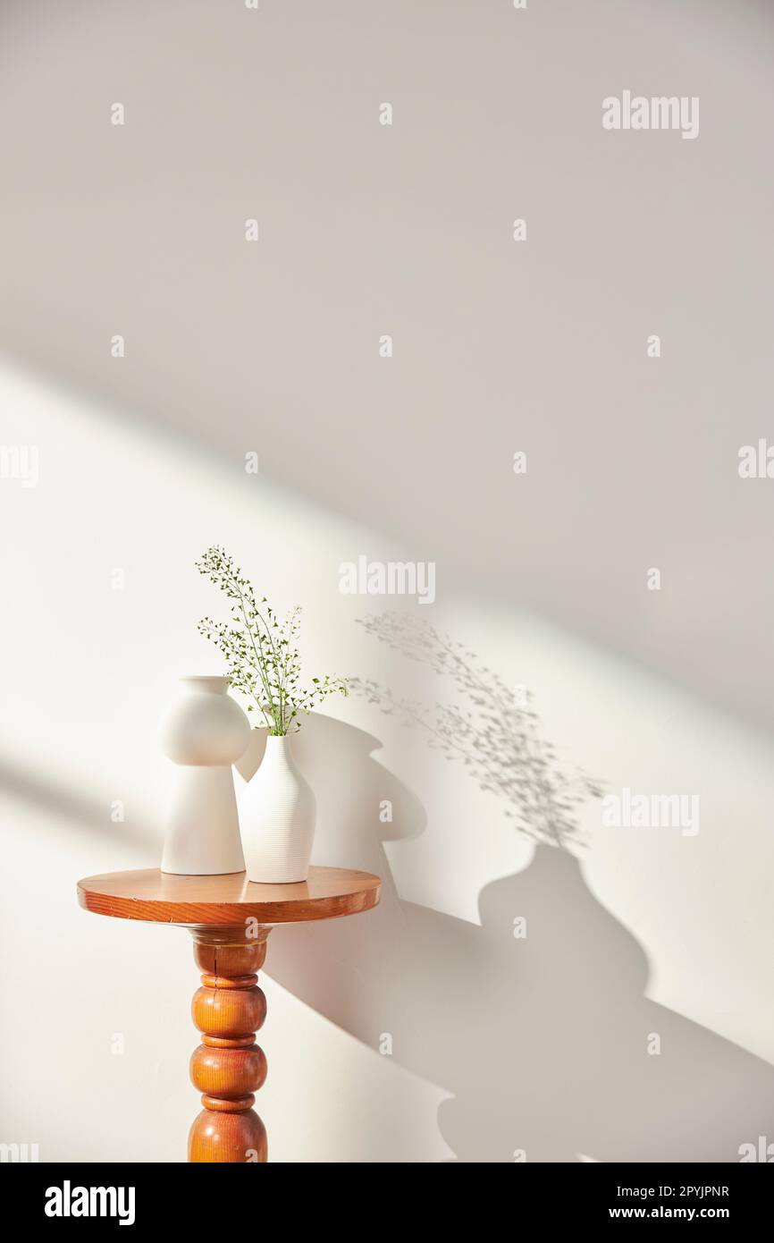 Vases and objects on the table in a warm room with sunlight coming in ...