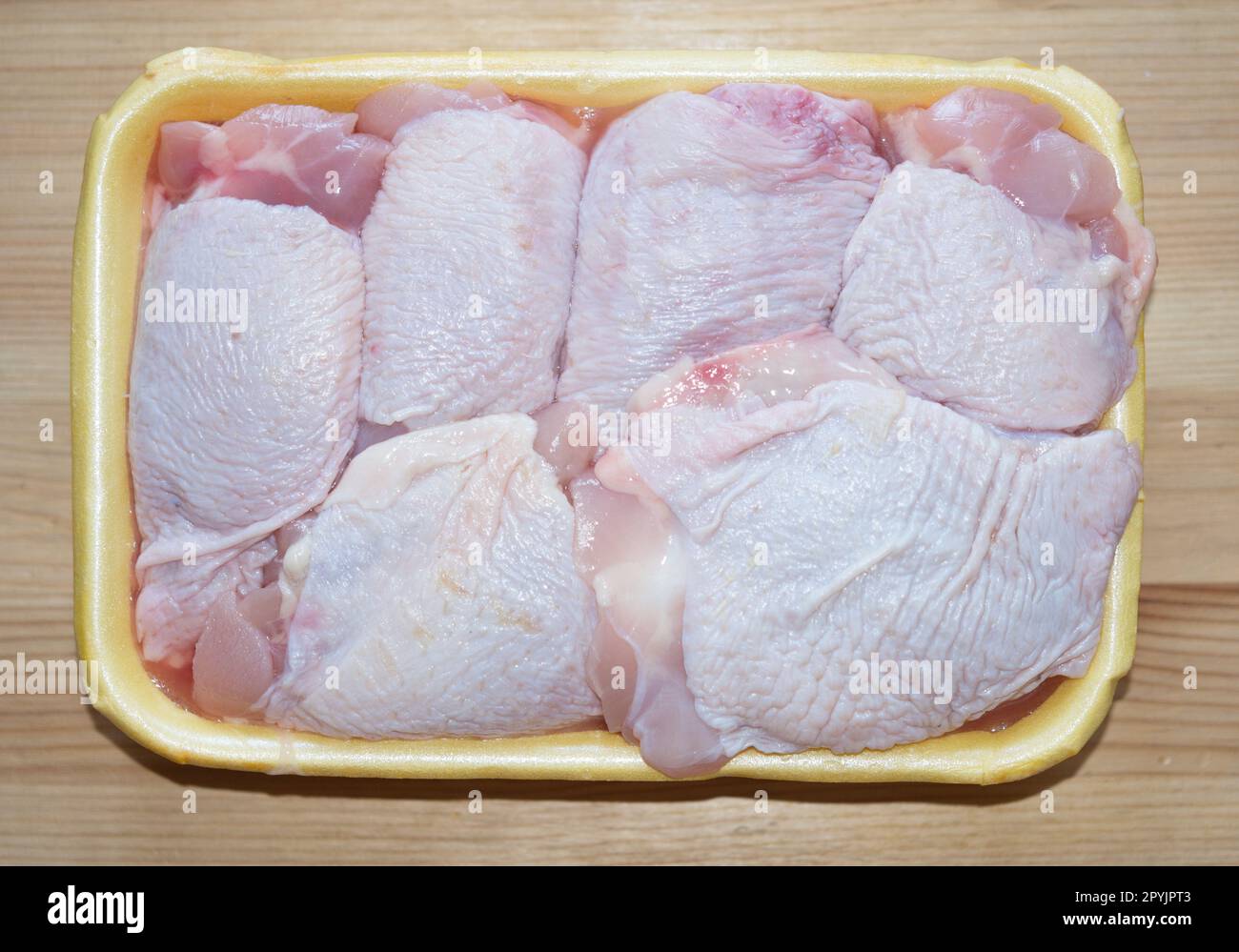 Chicken thighs in a tray. Top view Stock Photo - Alamy