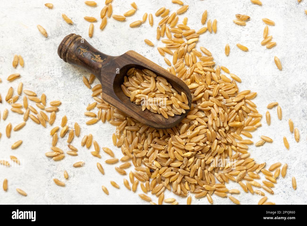 Wooden scoop of raw dry rye grain on white table top view Stock Photo ...