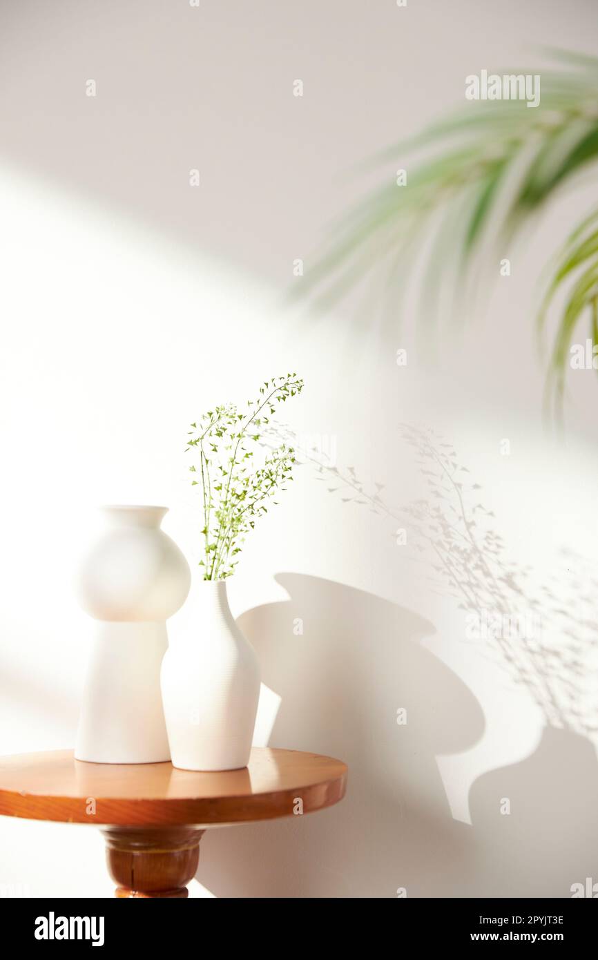 Vases and objects on the table in a warm room with sunlight coming in ...