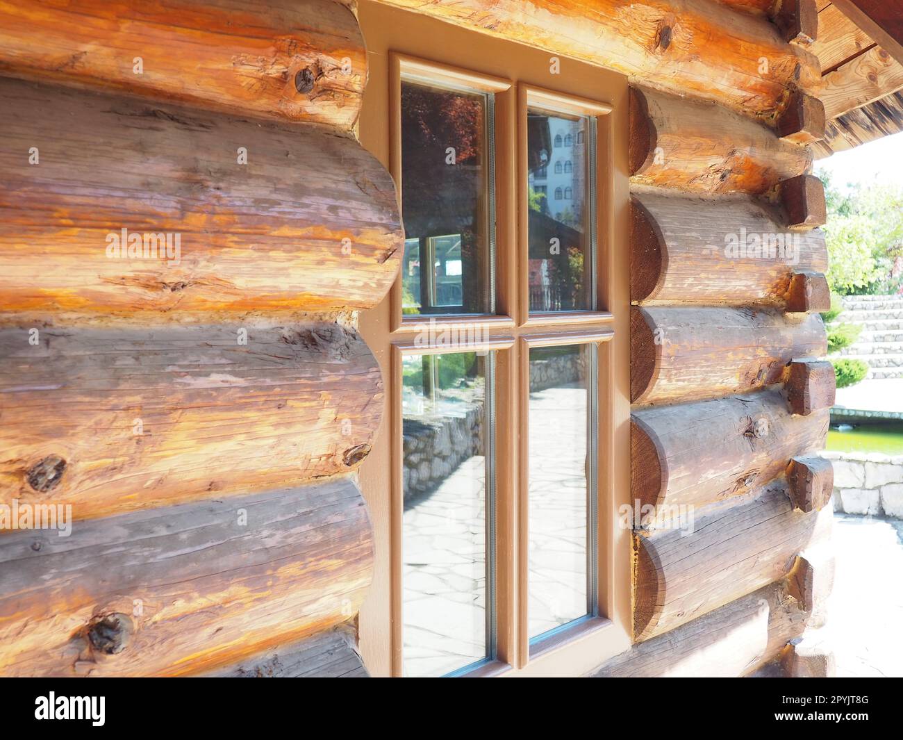 Fashionable log house close-up. Glass window with wooden frame. The ...