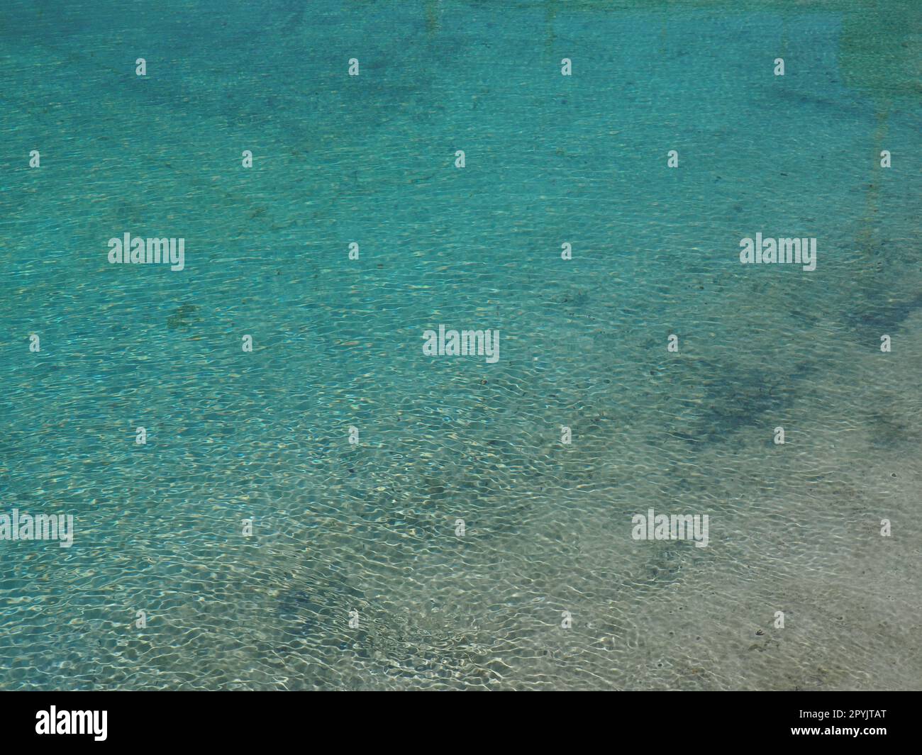 blue and turquoise water. Clear sea water with waves and sun glare. The ...