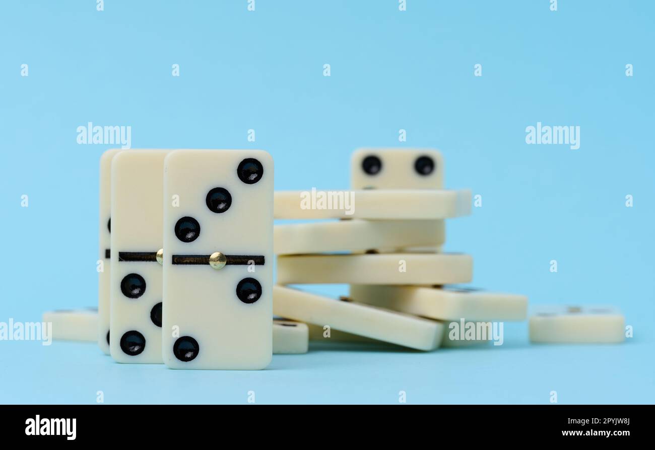 A stack of dominoes on a blue background, intellectual game Stock Photo ...