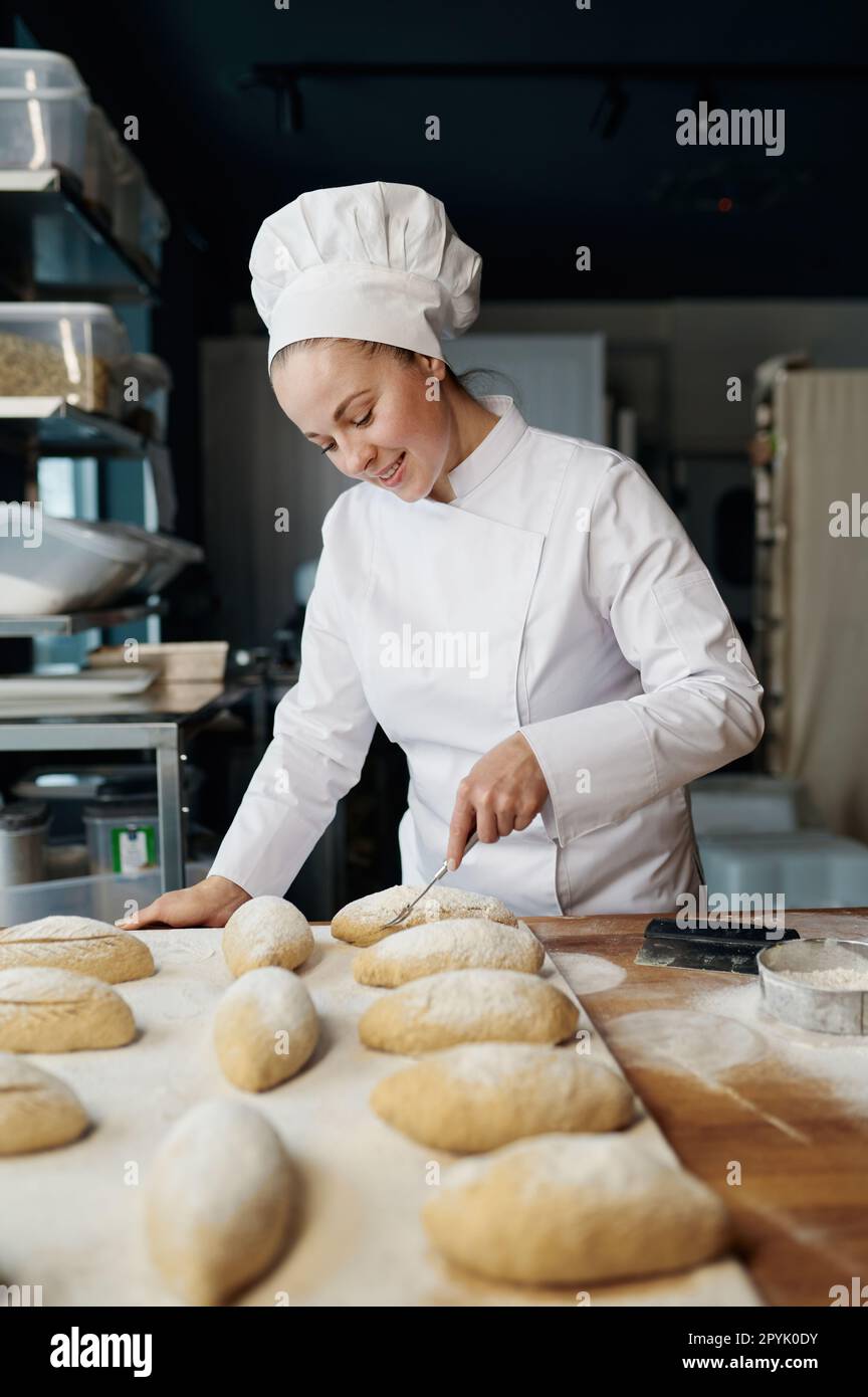 Woman baker decorating traditional yeast buns Stock Photo - Alamy