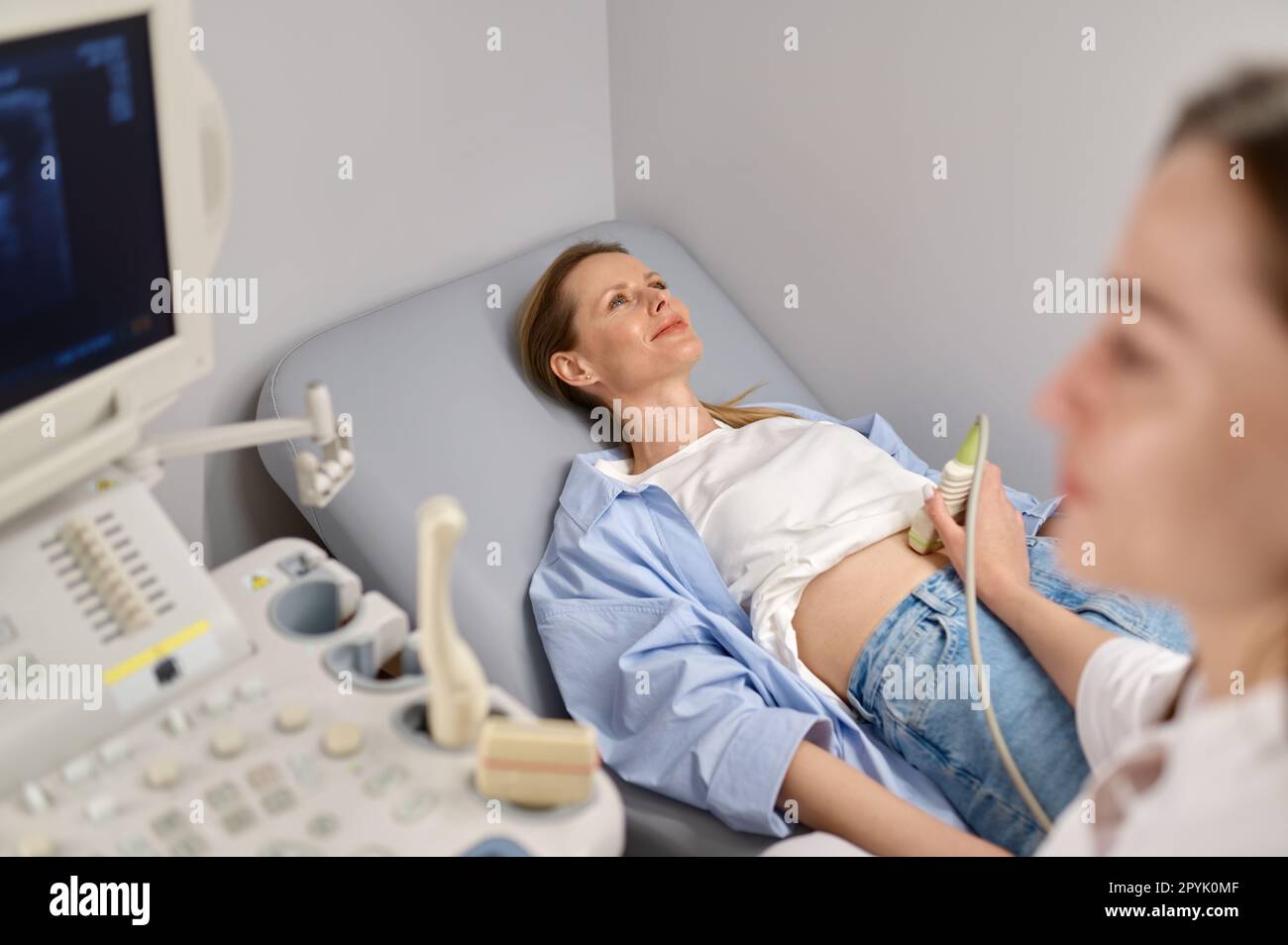Professional doctor examining his patient doing abdominal ultrasound ...